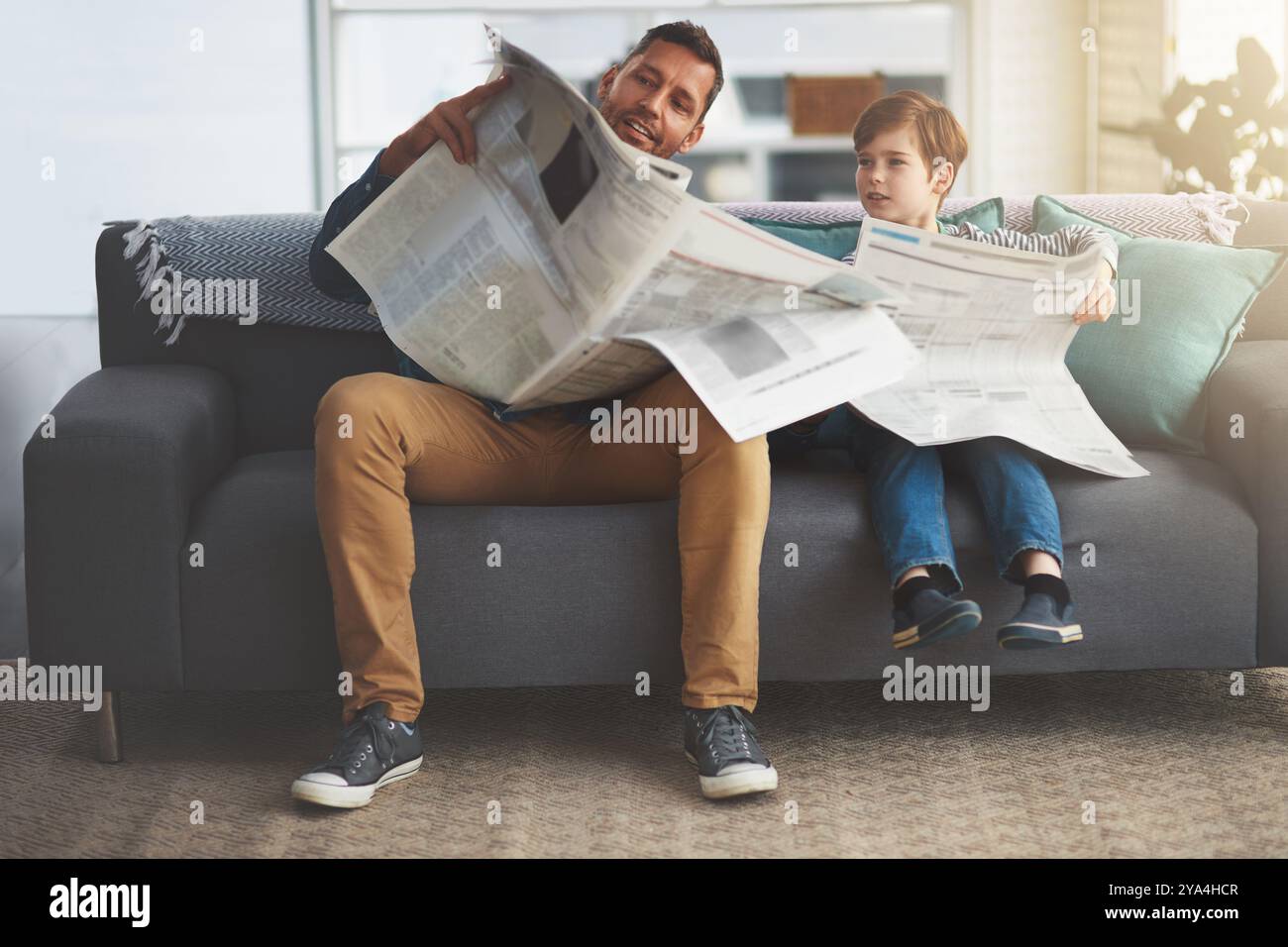 Father, kid or reading a newspaper on sofa in home for article ...