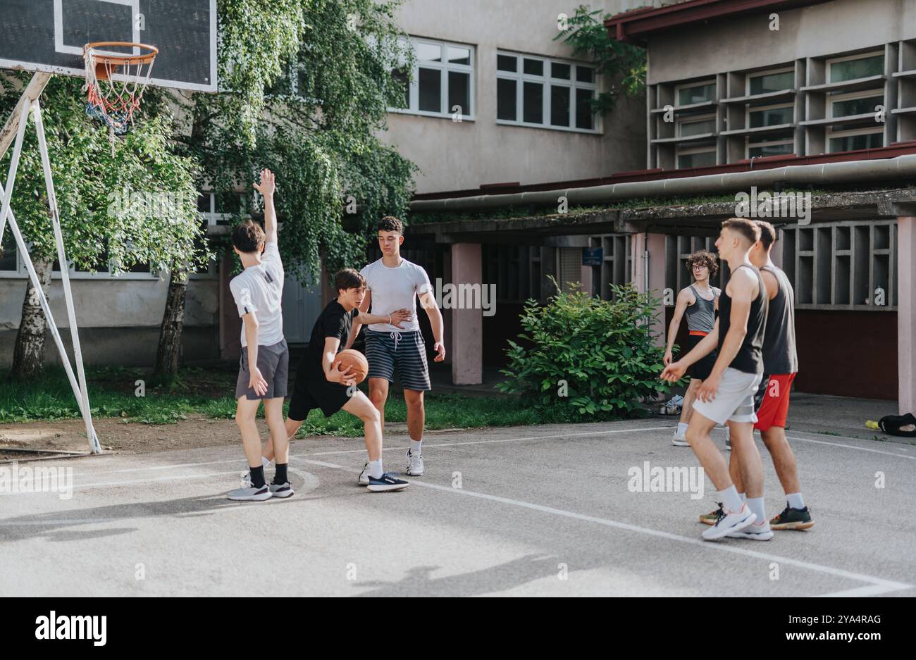 Group of friends enjoying a lively basketball game at an old ...