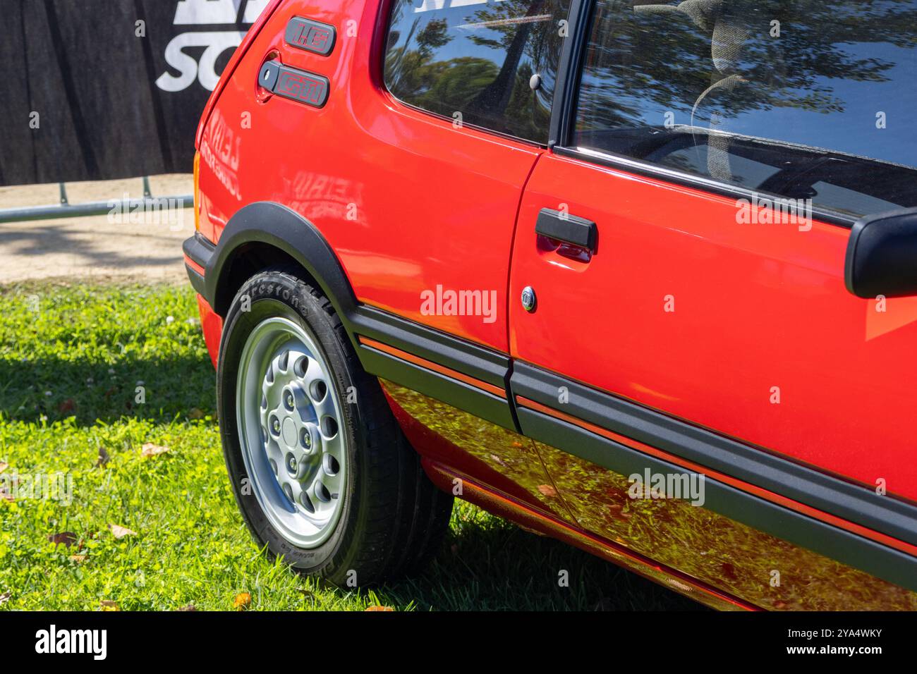 Close up of a red peugeot 205 gti parked on grass, showcasing its ...