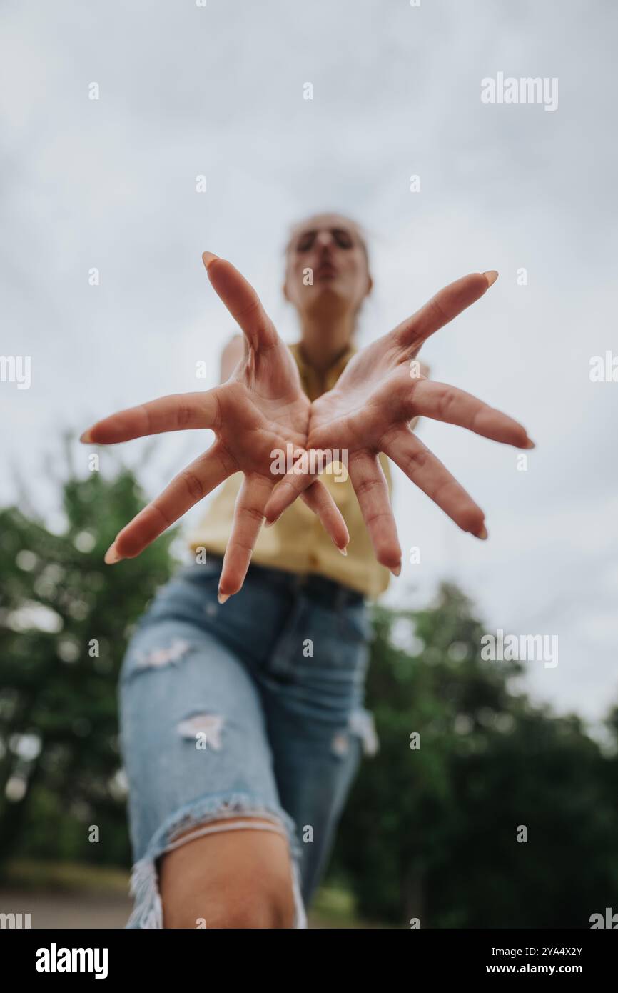 Young woman reaching out towards the camera in an outdoor setting Stock ...