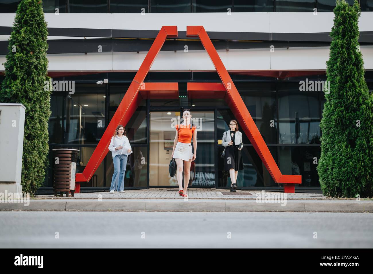 Group of businesswomen exiting office building with modern ...