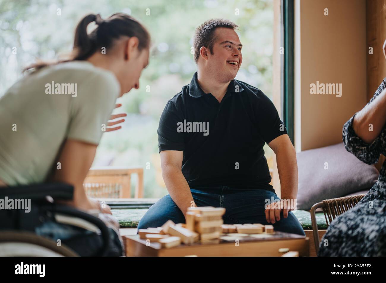 Boy with Down syndrome playing blocks with friends and family Stock ...