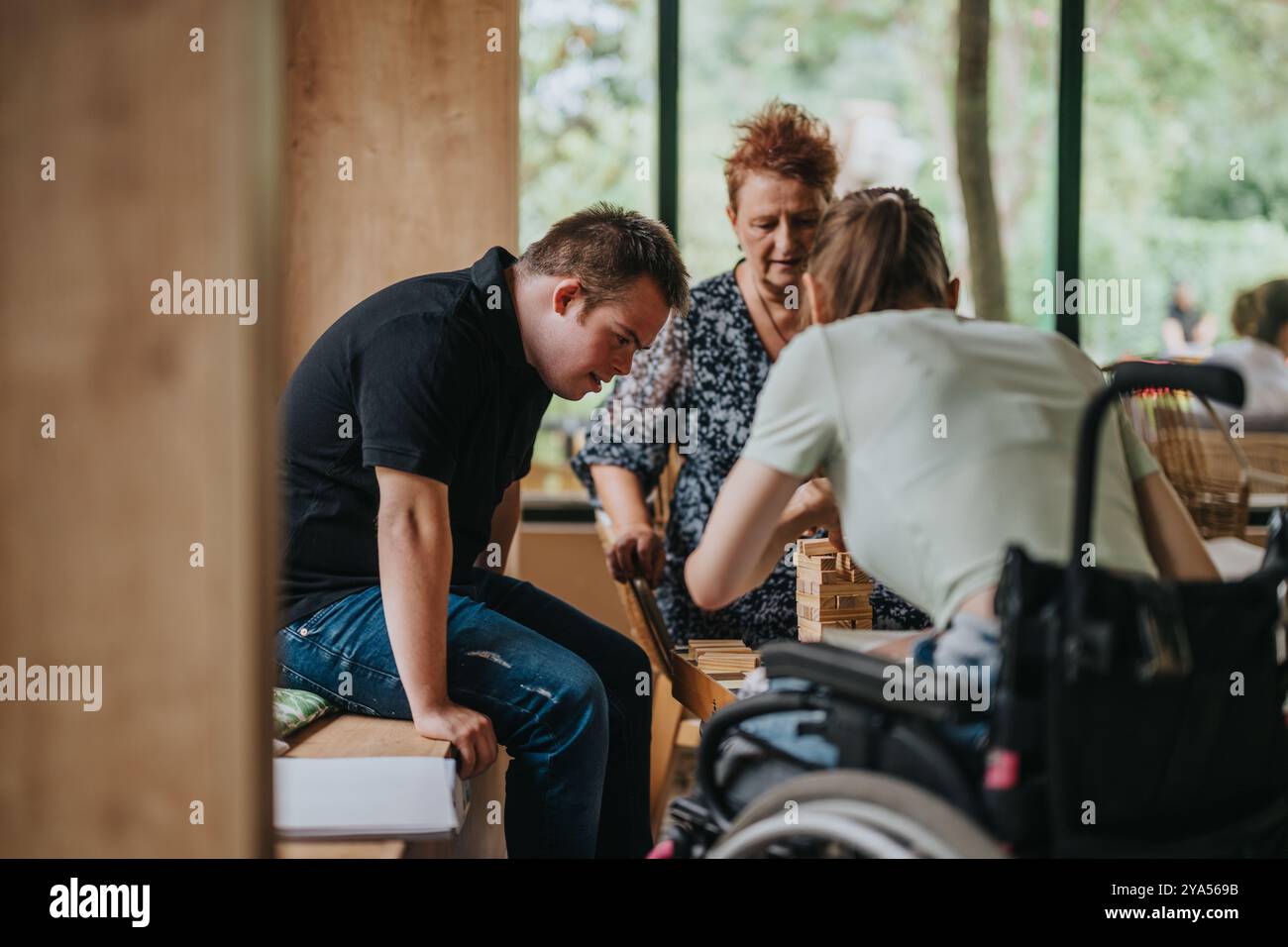 Boy with Down syndrome playing blocks with girl in wheelchair and ...