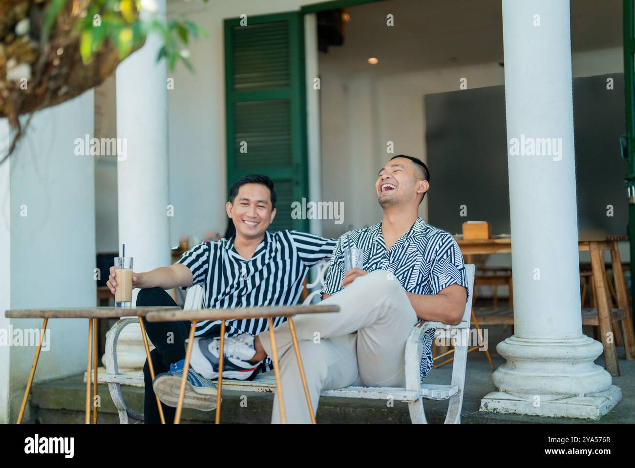 Joyful friends are truly enjoying a relaxing day together in a cozy and ...