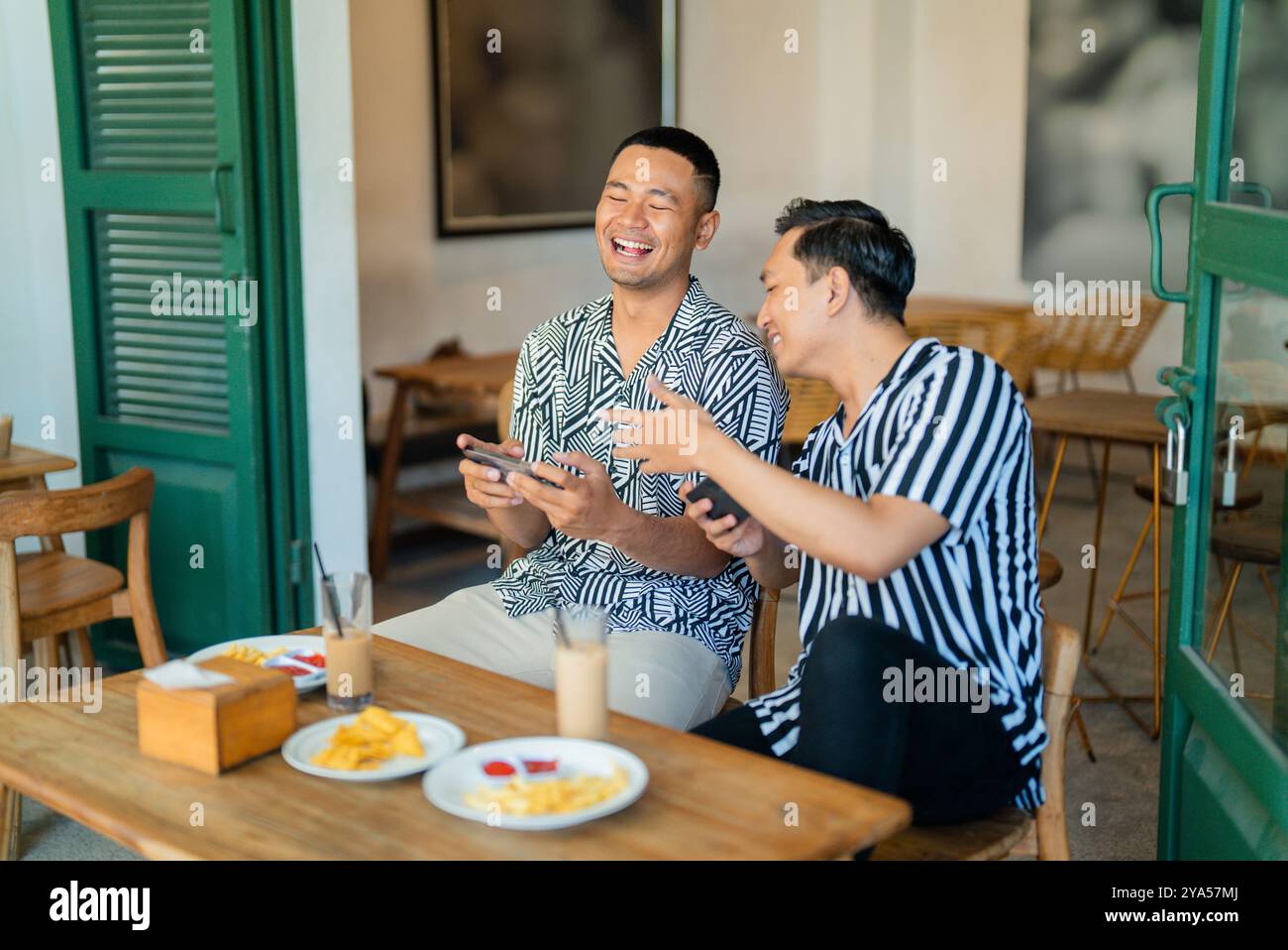 Joyful Friendship Over Breakfast: Two Friends Sharing Laughter and ...