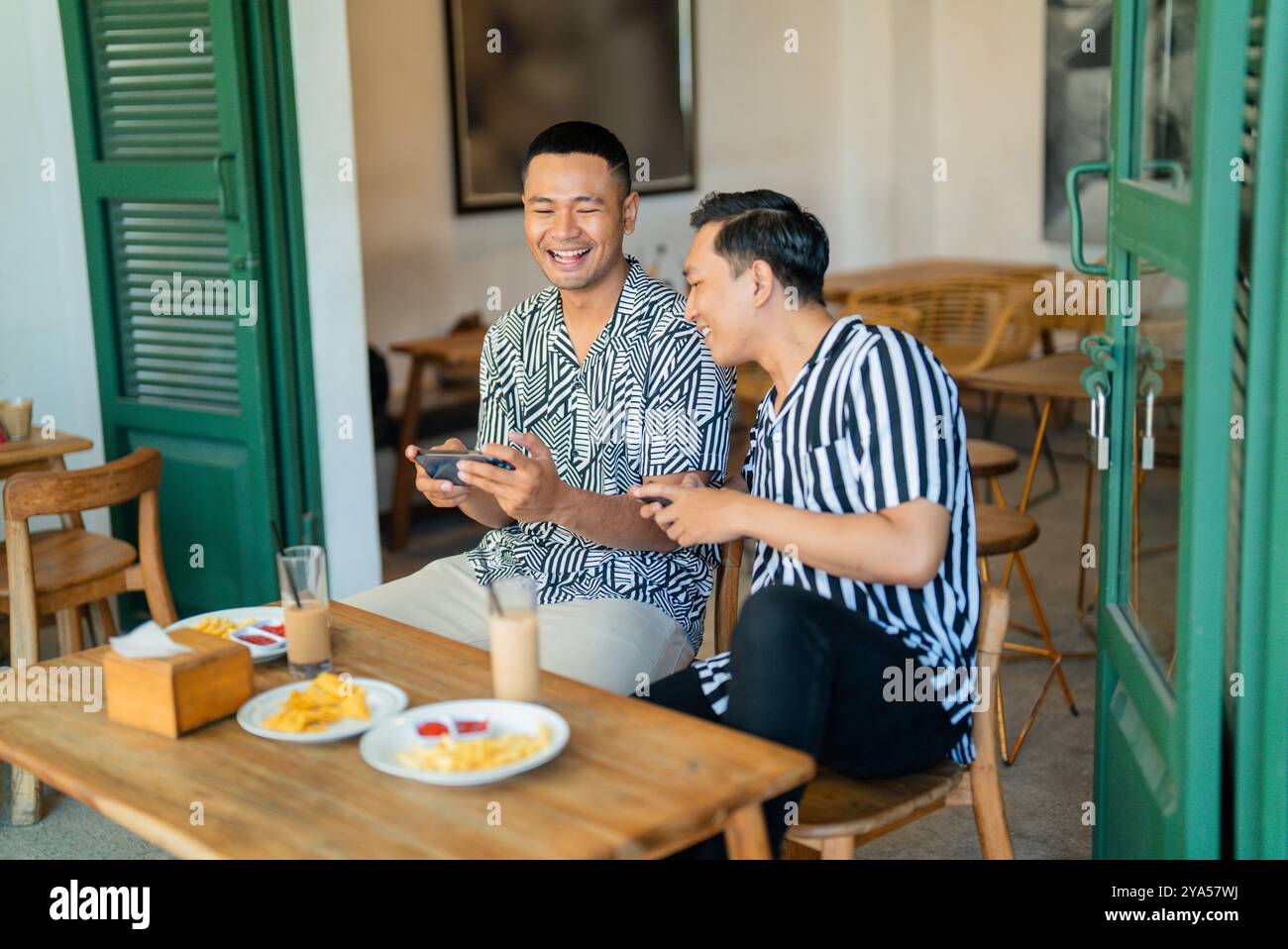 Two Friends Enjoying a Delicious Breakfast and Sharing Laughter in a ...