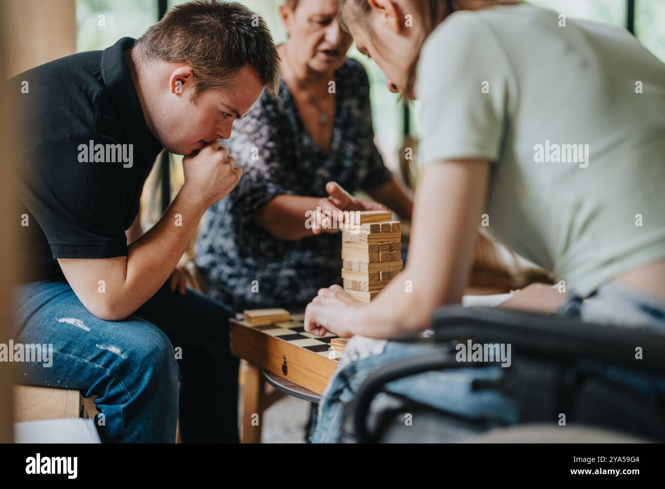 Boy with Down syndrome and friends playing blocks together Stock Photo ...
