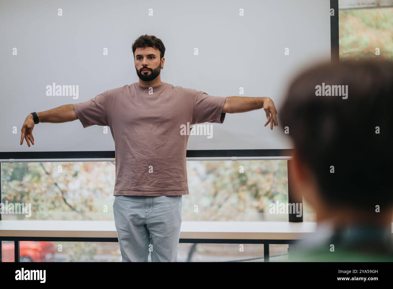 Instructor demonstrating arm movement to a classroom of students Stock ...