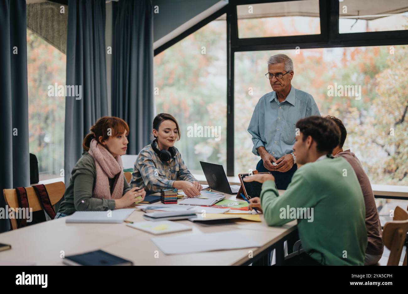 University students collaborate with professor on group project Stock ...