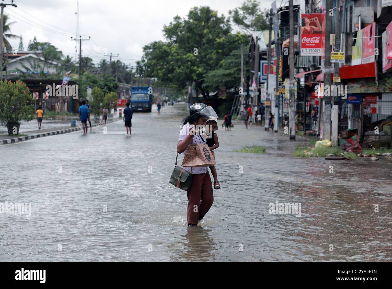 Colombo, Sri Lanka. 12th Oct, 2024. People walk on a flooded road after ...