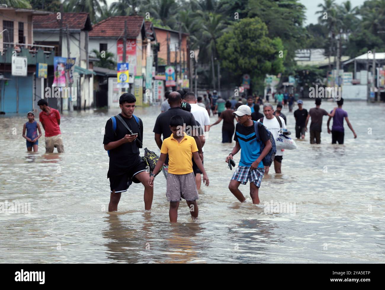Colombo, Sri Lanka. 12th Oct, 2024. People walk on a flooded road after ...