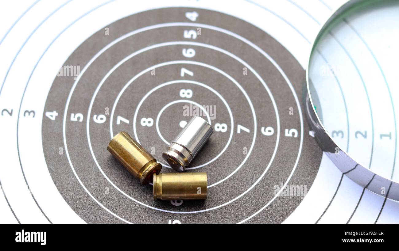 Empty bullet casing on a shooting target, with a part of magnifying ...