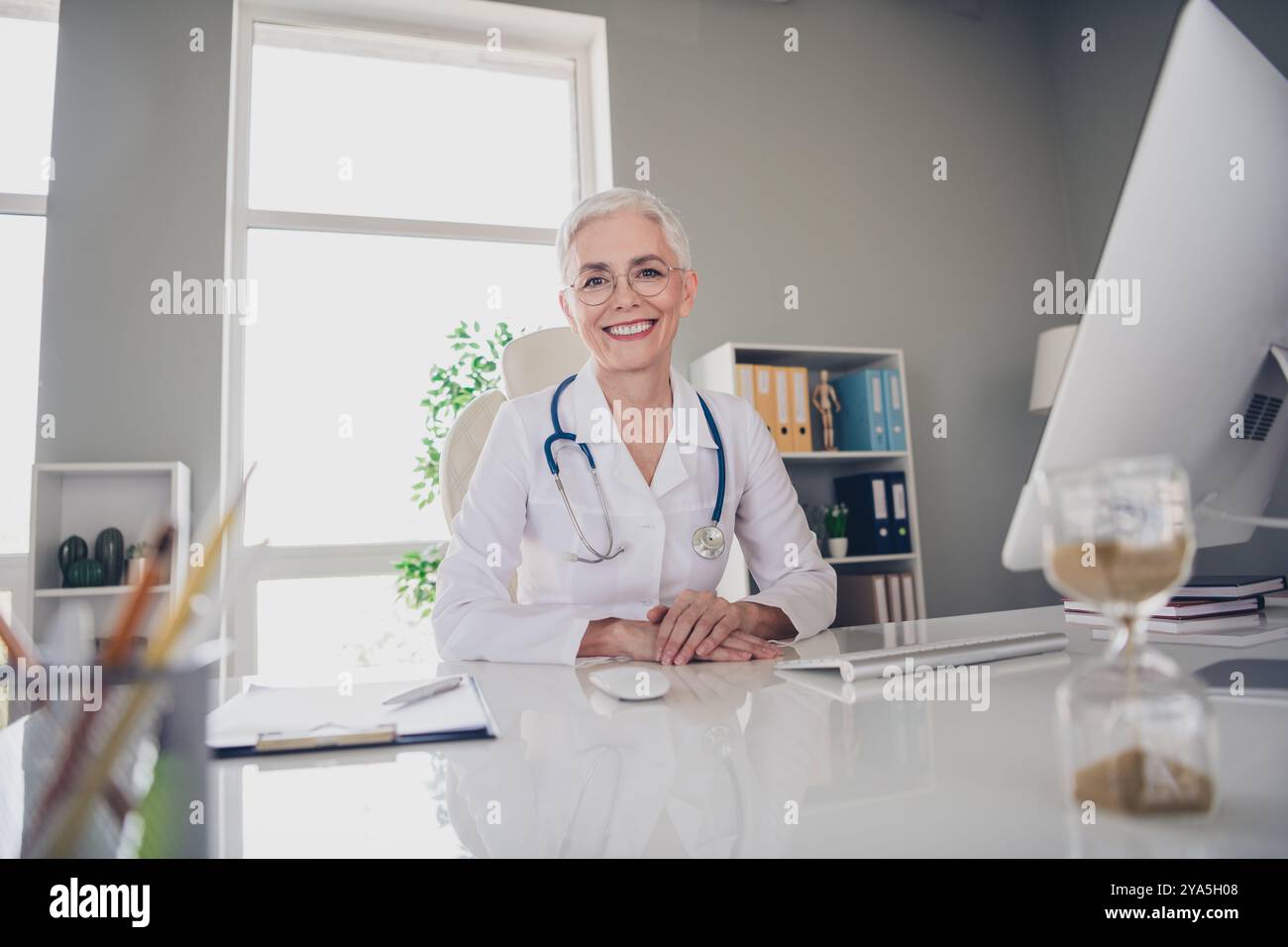 Photo of family doc successful professional mature lady doctor sit table consultation wear white ...