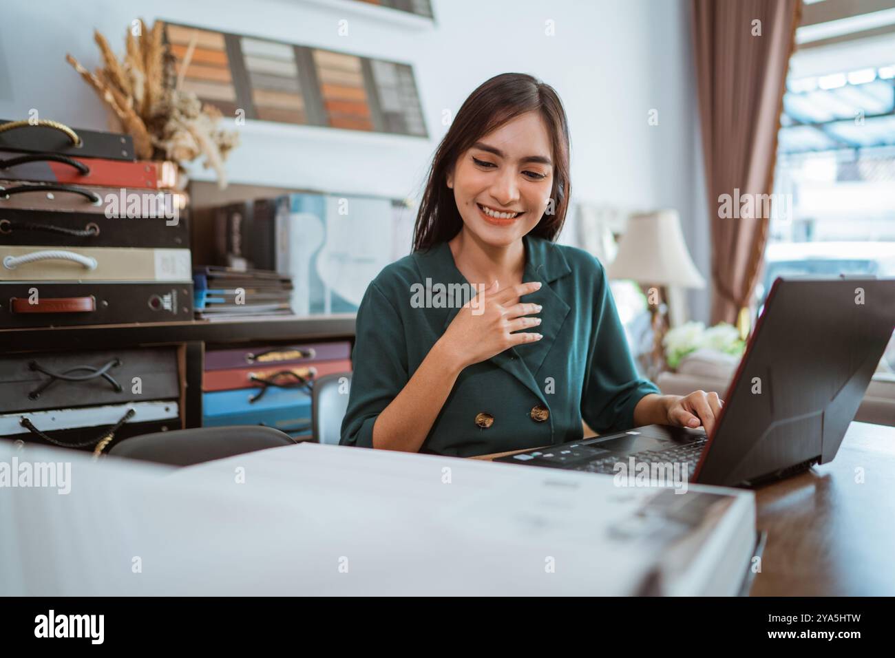beautiful asian shopkeeper smiling while looking at window treatments ...