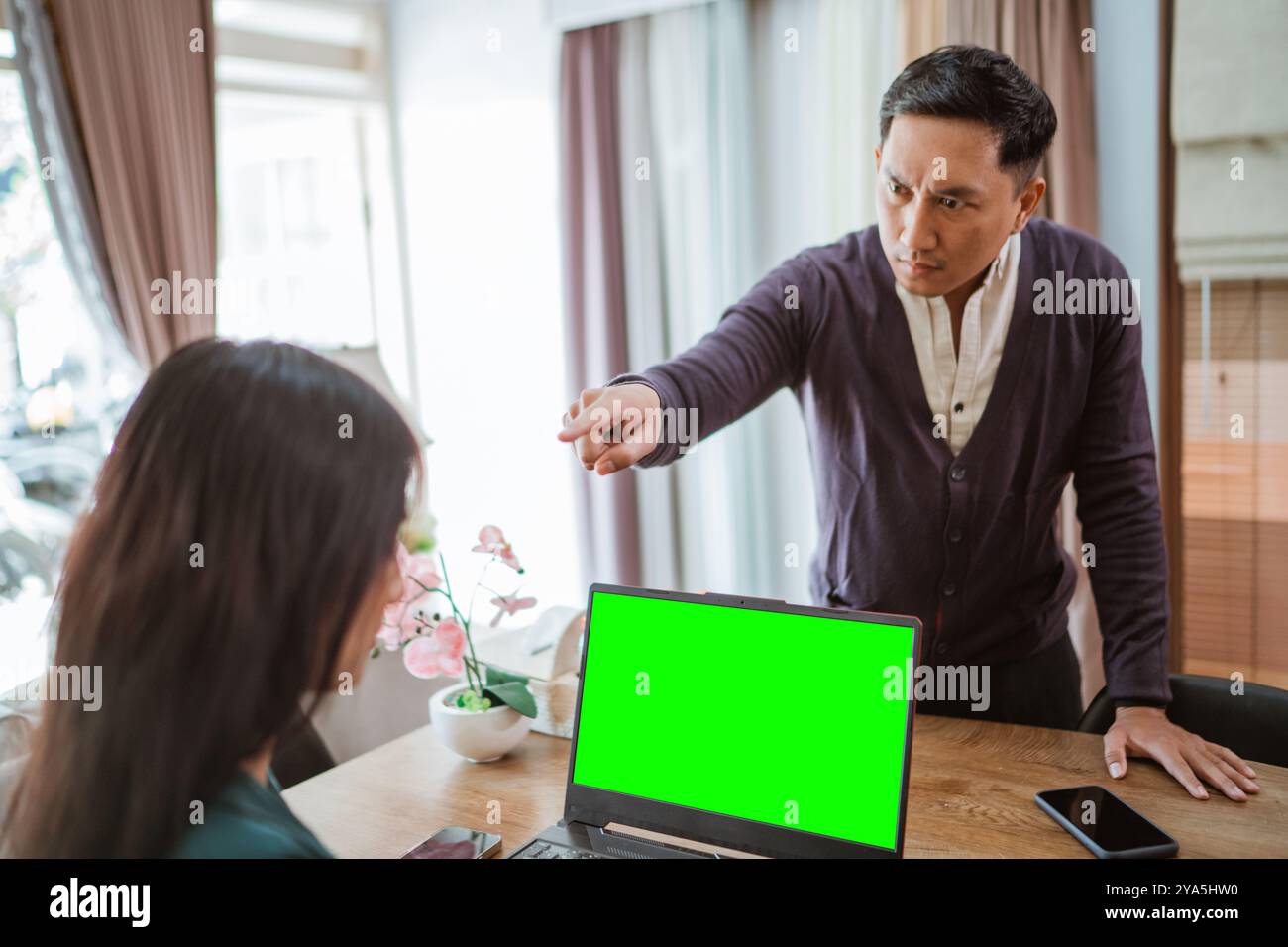 grumpy asian shop owner pointing on his employee while scolding at her ...