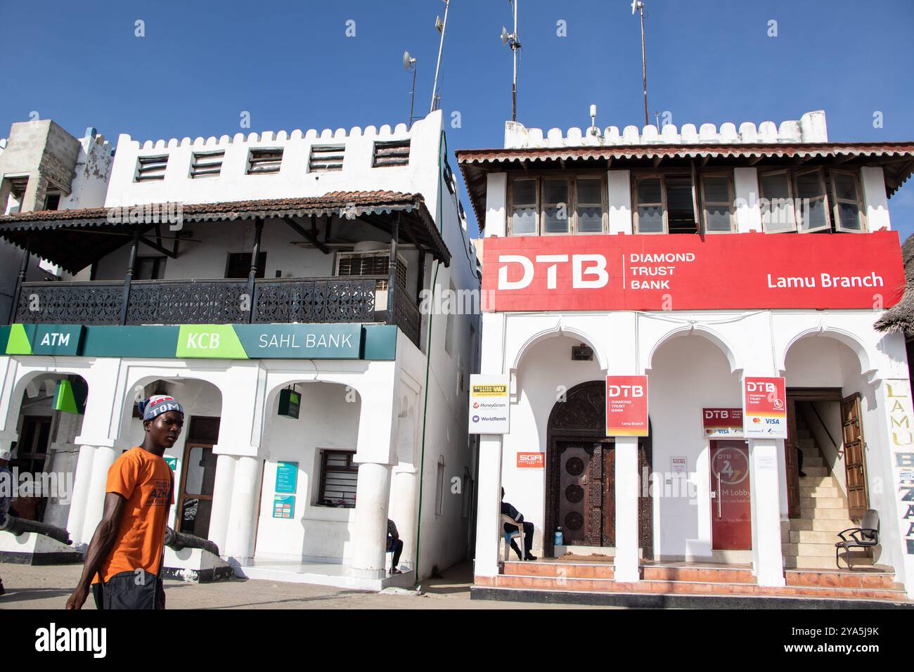 A man walks along the main street of Lamu Island. Lamu Island, a UNESCO ...