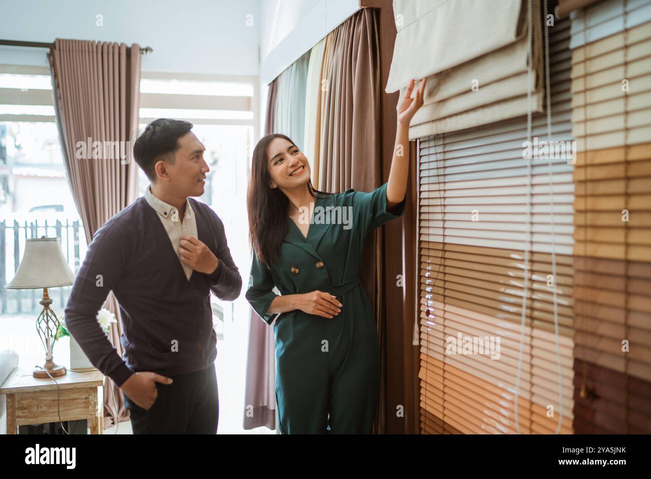 asian shopkeeper showing to the asian customer the roman blinds fabric ...
