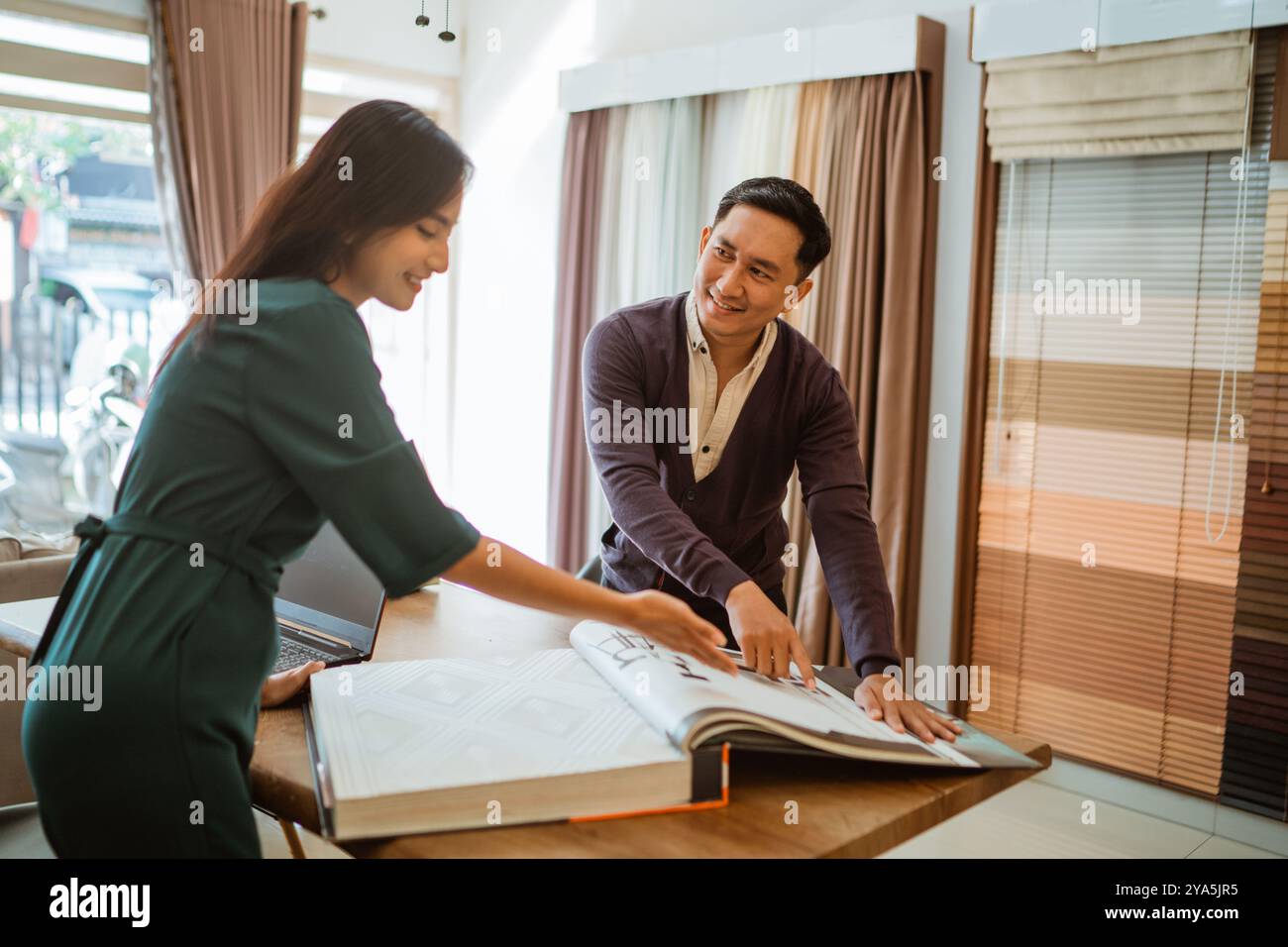 the male customer pointing on the catalogue book to get explanation ...