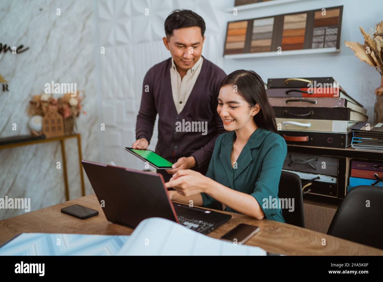 male shop crew showing the digital tablet to the female shop crew Stock ...
