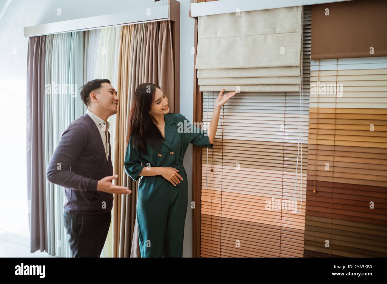 asian female shopkeeper explaining the different types of blinds Stock ...