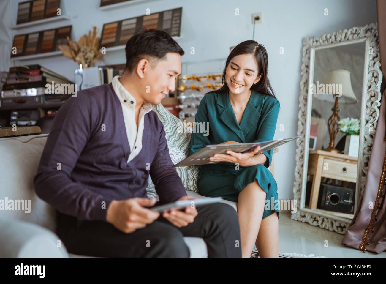 female shopkeeper helping the male customer choosing the types of ...