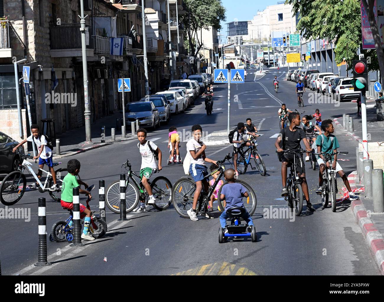 Jerusalem, Israel. 12th Oct, 2024. Ethiopian children ride bicycles on ...