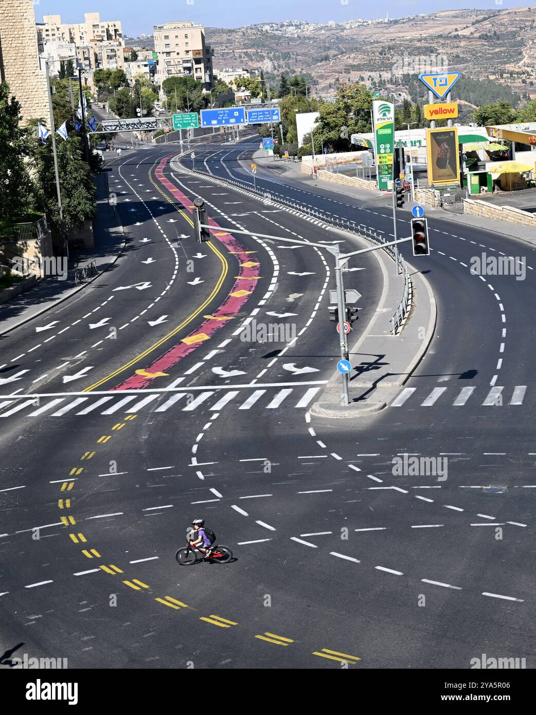 Jerusalem, Israel. 12th Oct, 2024. A girl rides a bicycle on an empty ...