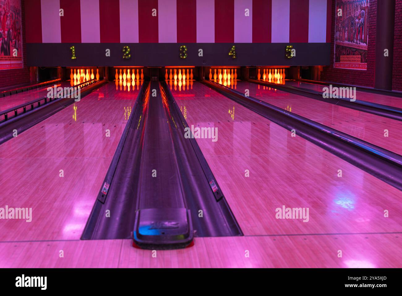 Empty bowling alley with five lanes illuminated by colorful lighting ...