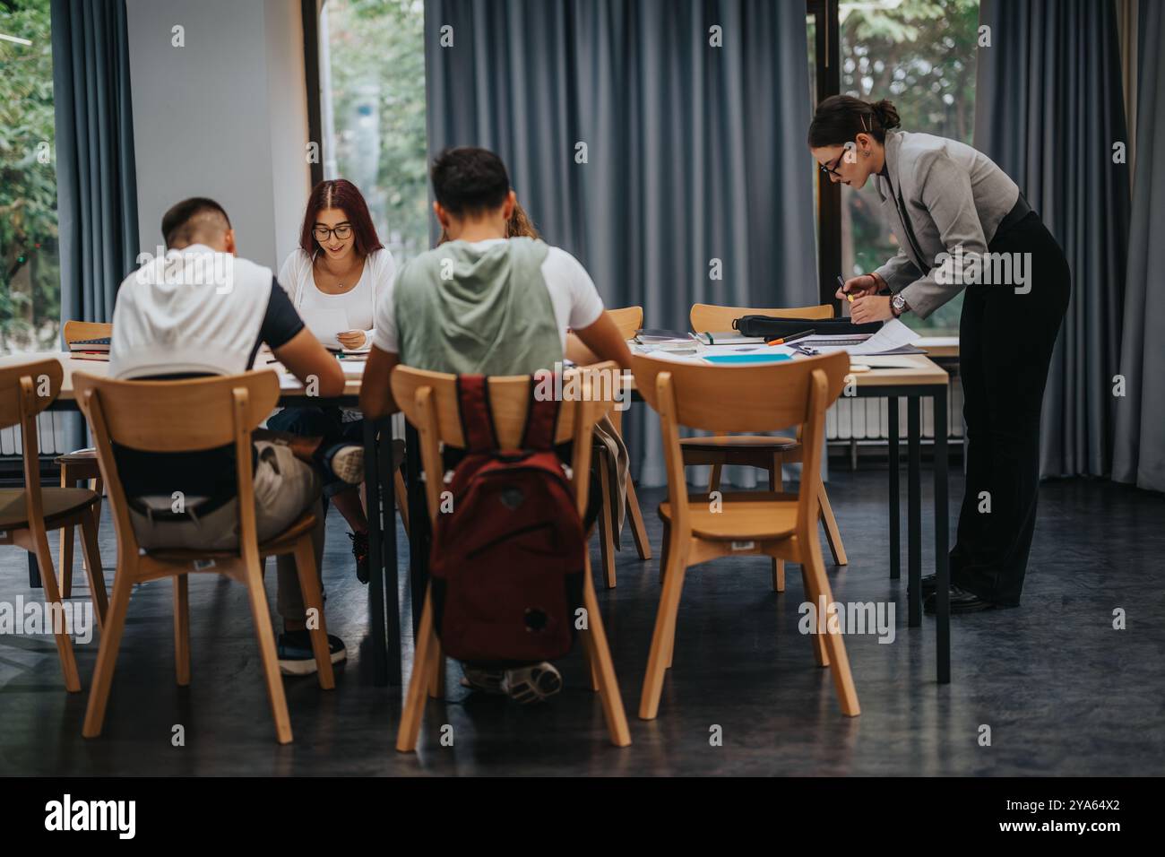Teacher assisting students in a modern educational classroom setting ...