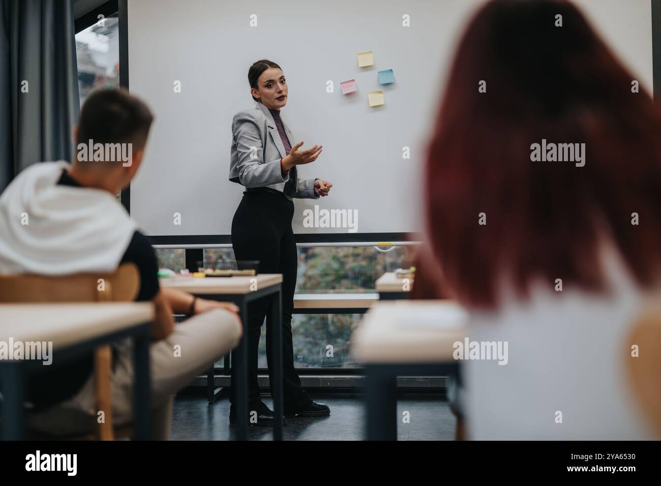 Teacher engaging with attentive students in modern classroom setting ...