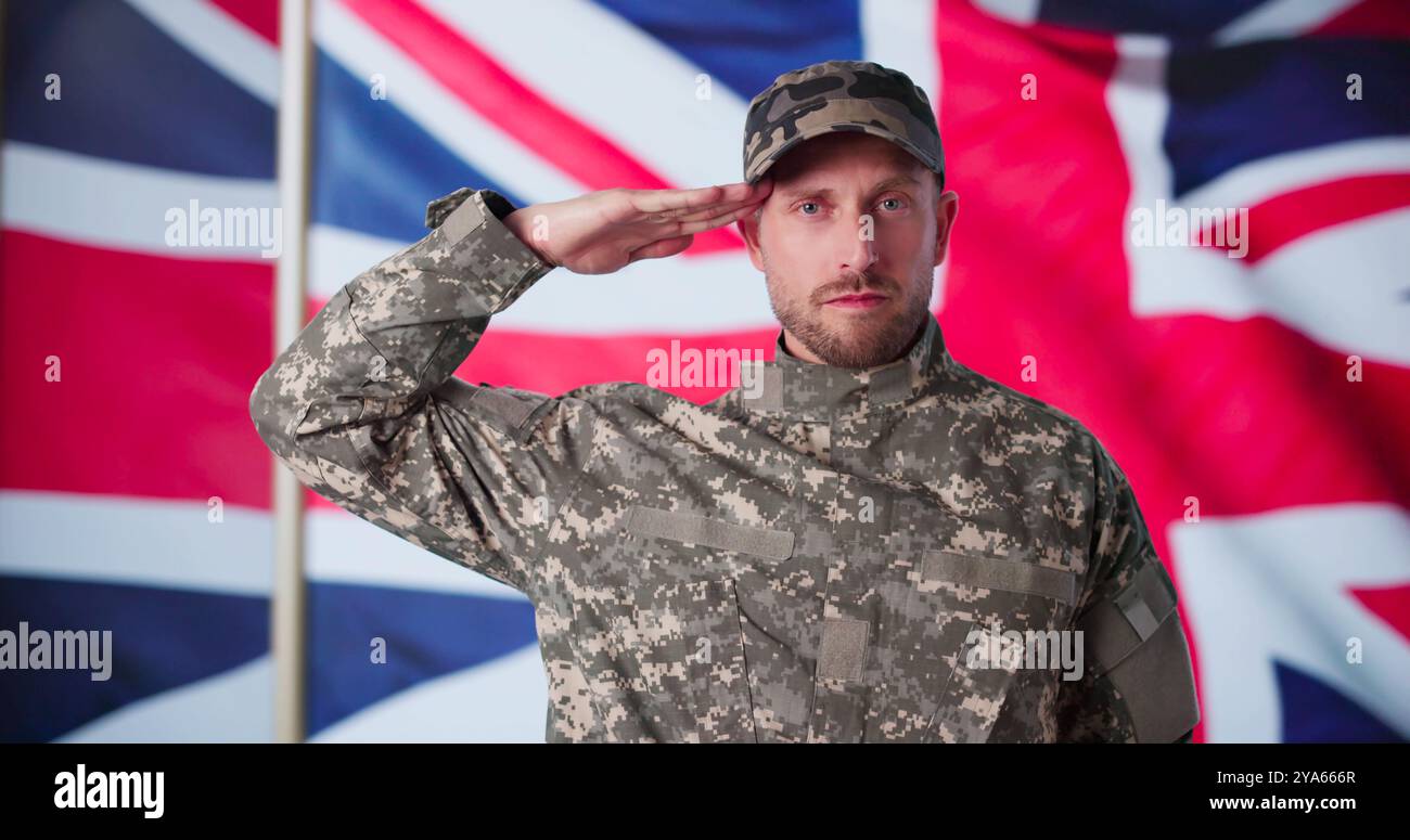 Solider Saluting In Front Of The British Flag Stock Photo - Alamy