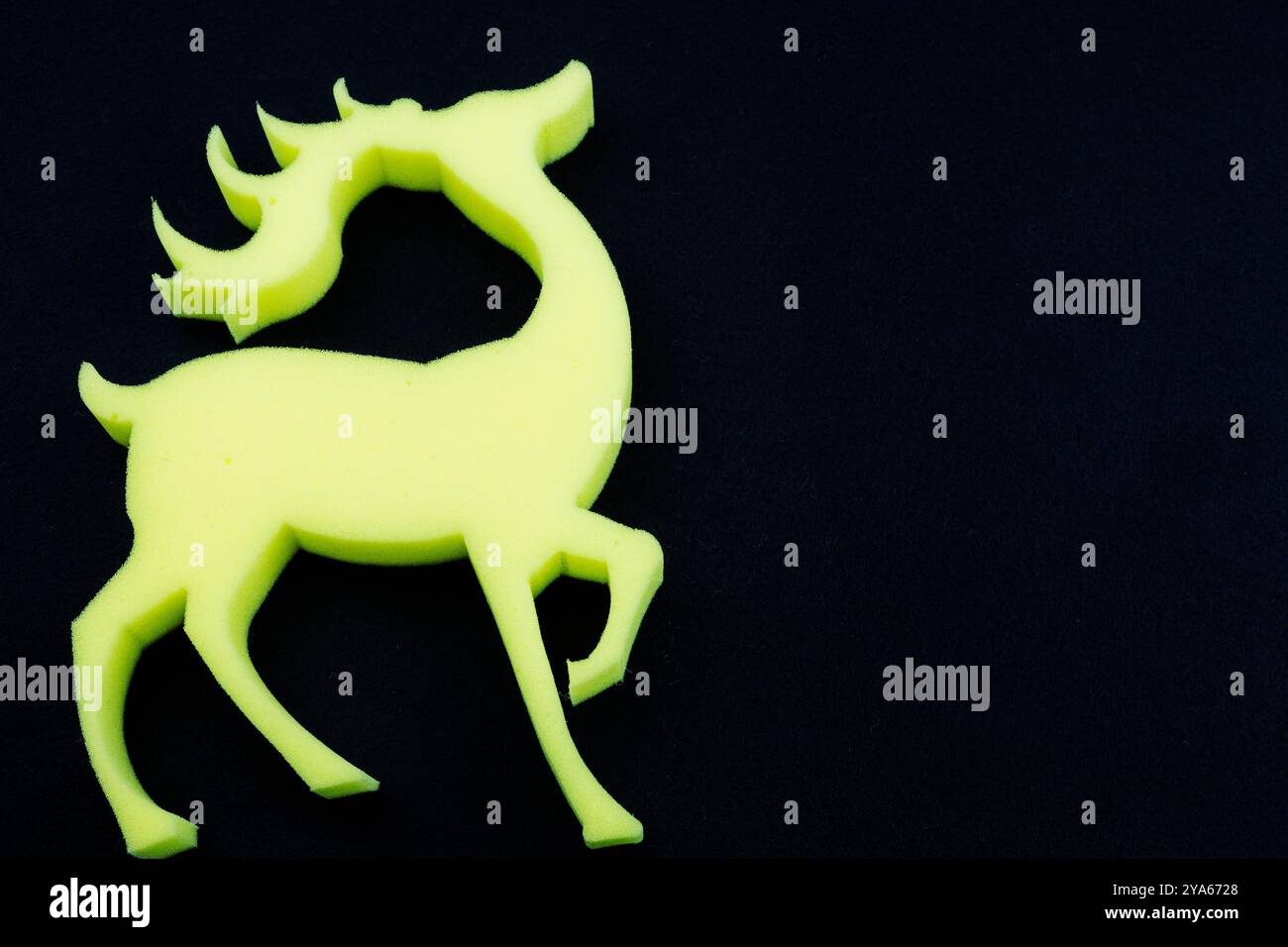 A vibrant yellow deer with prominent antlers stands out beautifully ...