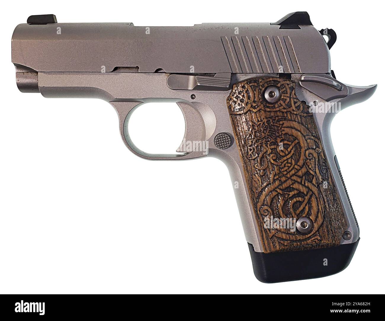Shiny Silver metal gun with engaved Celtic grip Stock Photo - Alamy