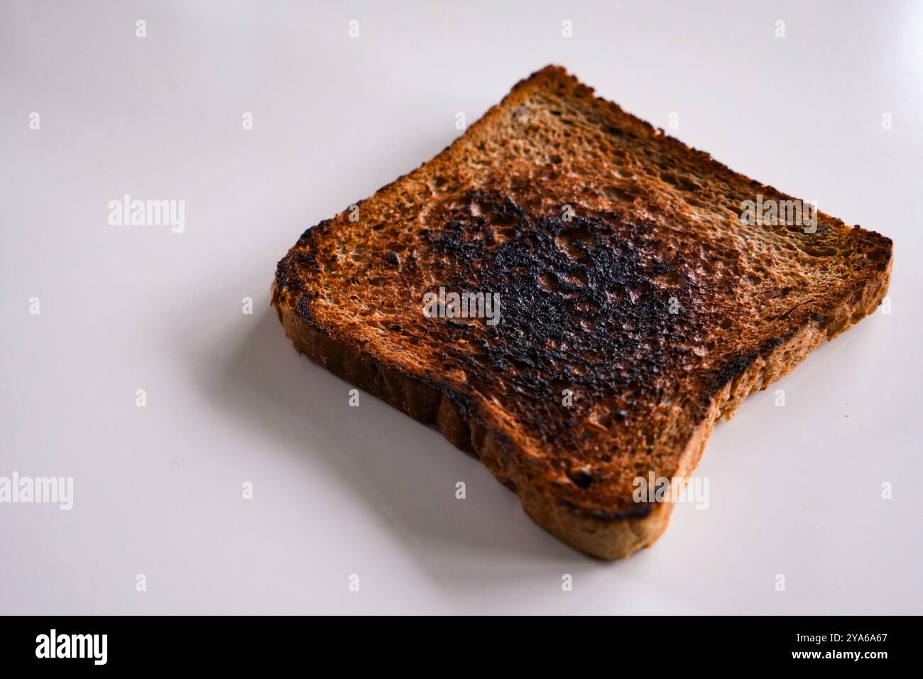 Burnt slice of toast bread isolated on white with text space without ...