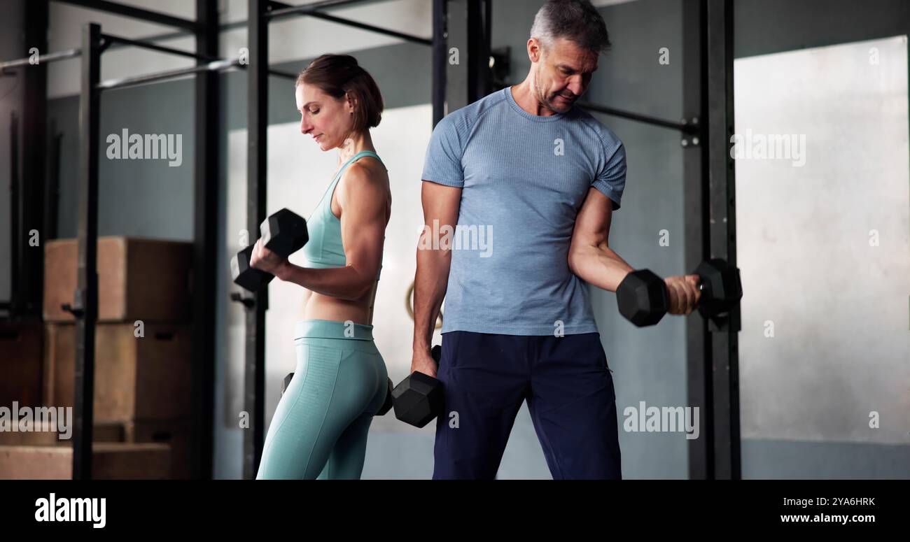 Fitness Couple Doing Weight Training Muscle Exercise In Gym Stock Photo ...