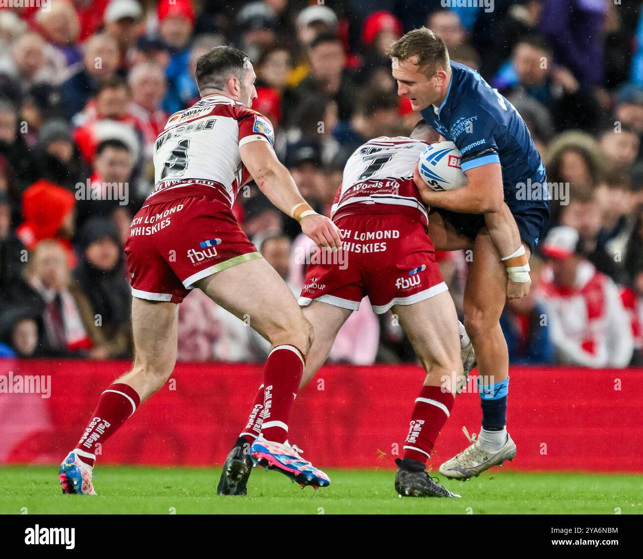 Jez Litten of Hull KR is tackled by Harry Smith of Wigan Warriors ...