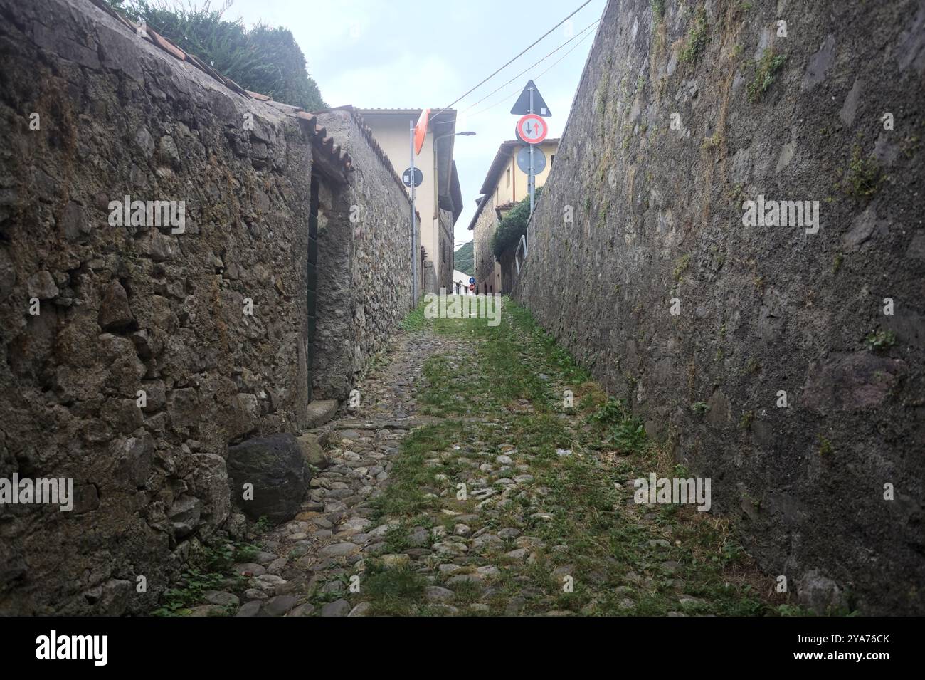 Sloppy cobbled path between a stone walls in a town in the mountains ...
