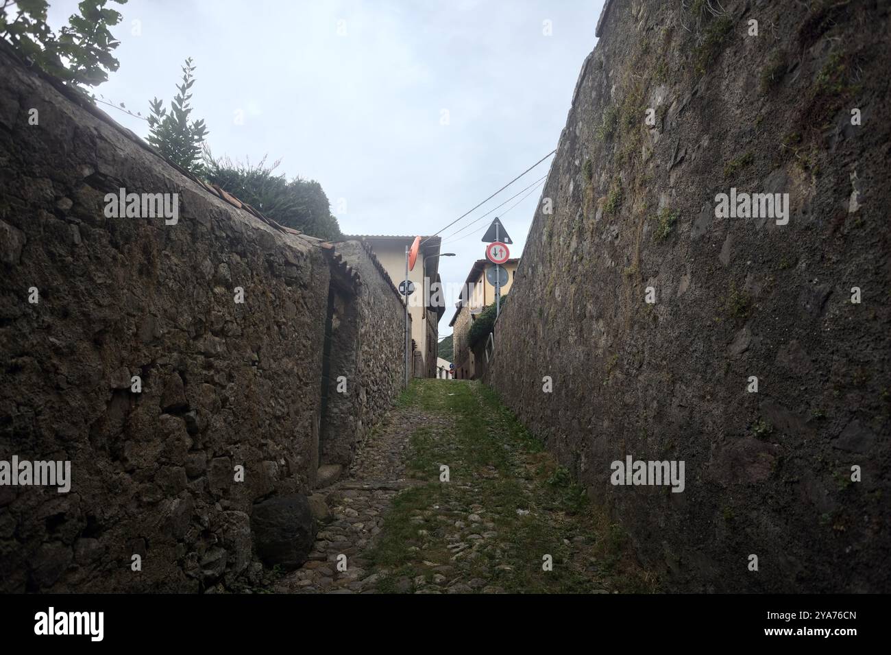 Sloppy cobbled path between a stone walls in a town in the mountains ...