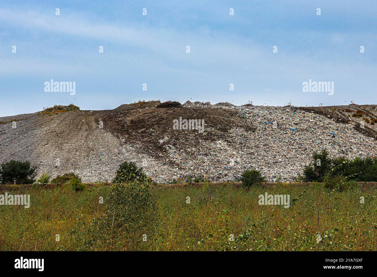 A landfill site with huge piles of waste and garbage, located in a ...