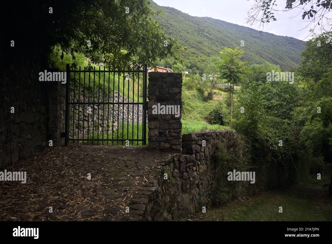 Entrance gate by the edge of a sloppy path in a park Stock Photo - Alamy