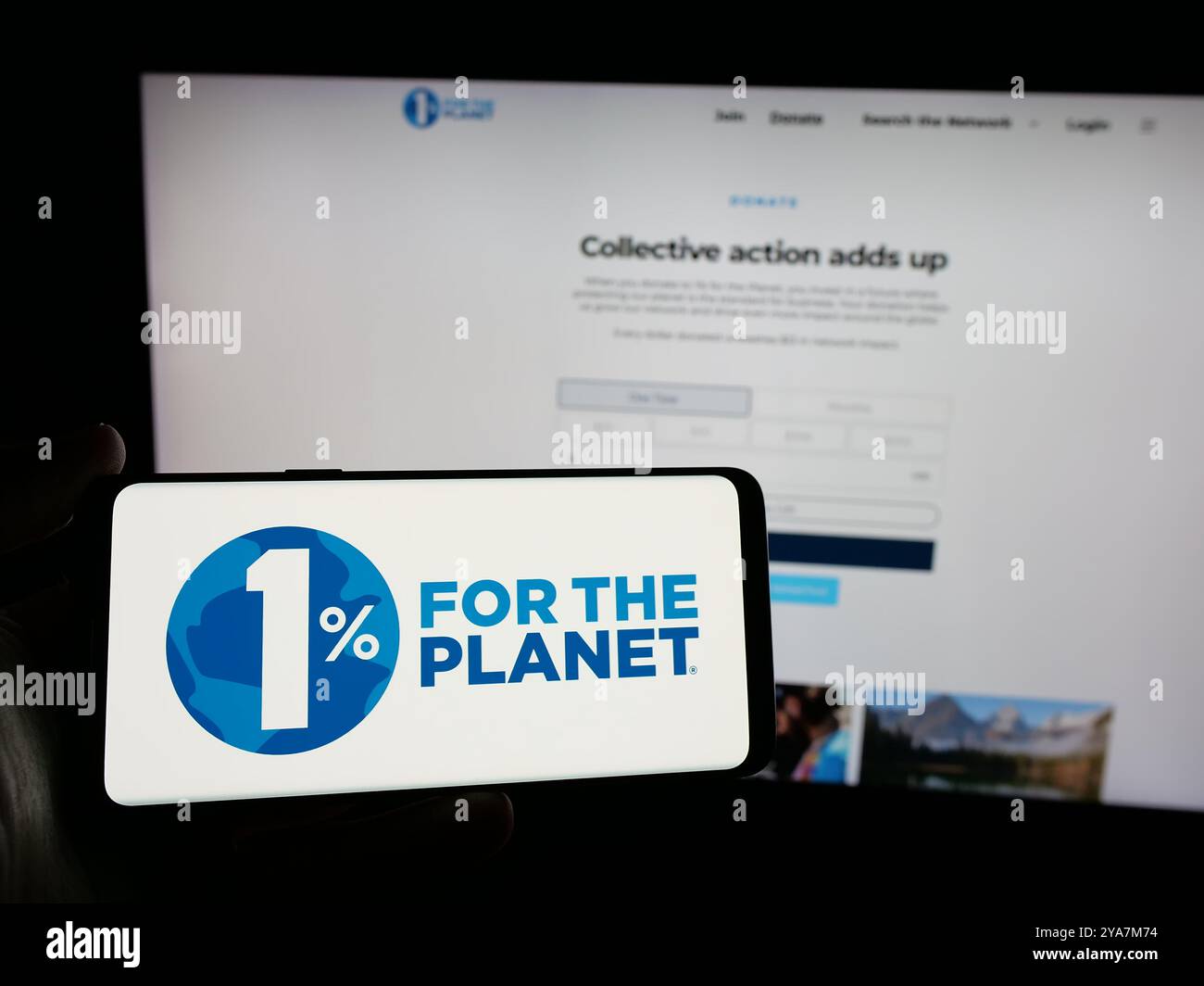 Person holding smartphone with logo of organization One Percent for the ...