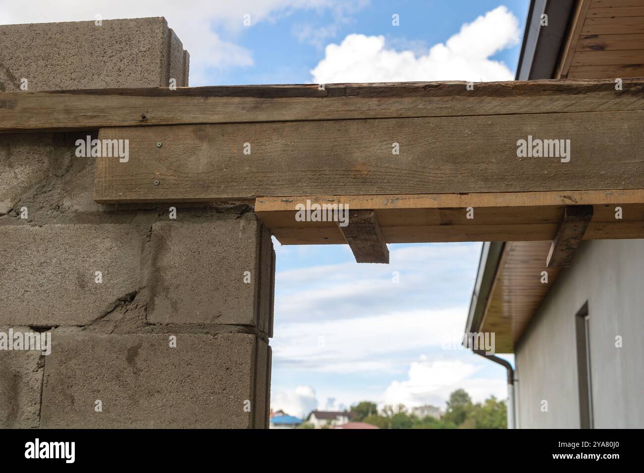 A wooden beam with a nail fastened to the concrete wall, an exterior ...