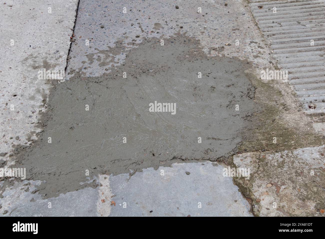 An old concrete slab on the sidewalk with cement cracks and areas that ...