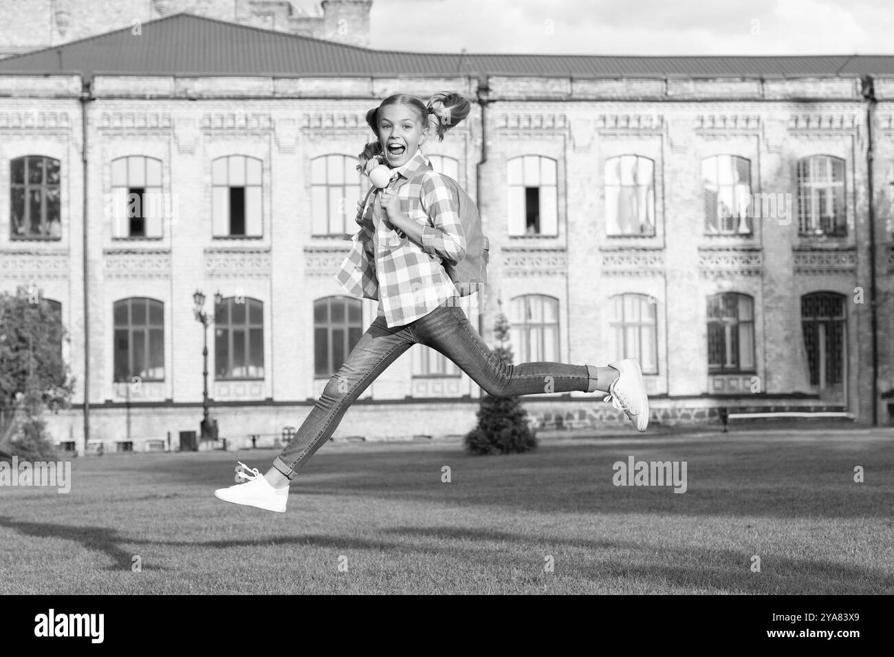 Happy active teenage girl jumping in school yard outdoors Stock Photo ...