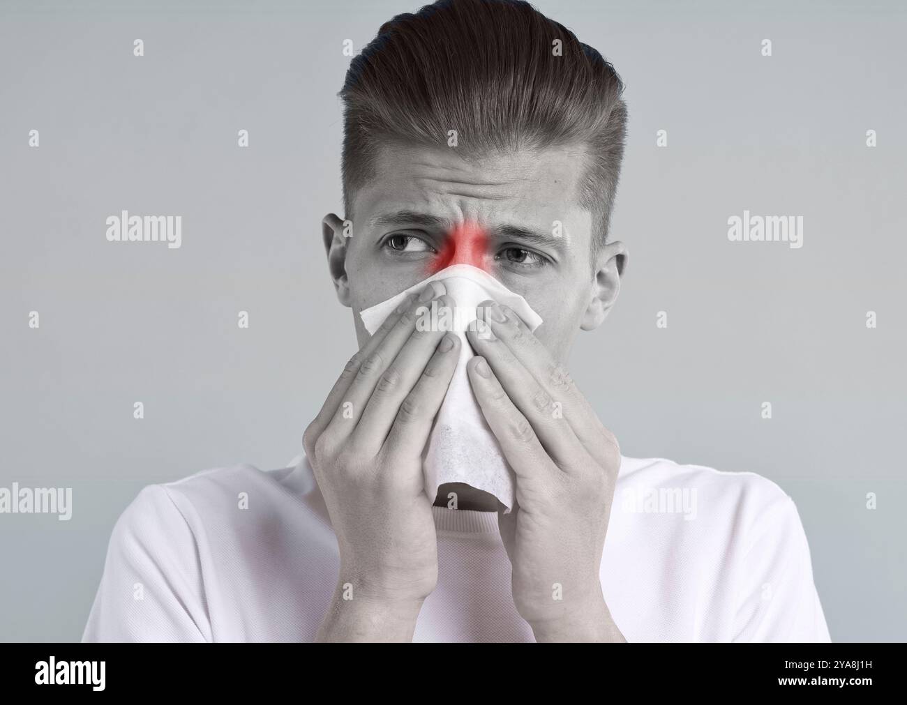 Young man with tissue suffering from sinusitis. Black and white effect ...
