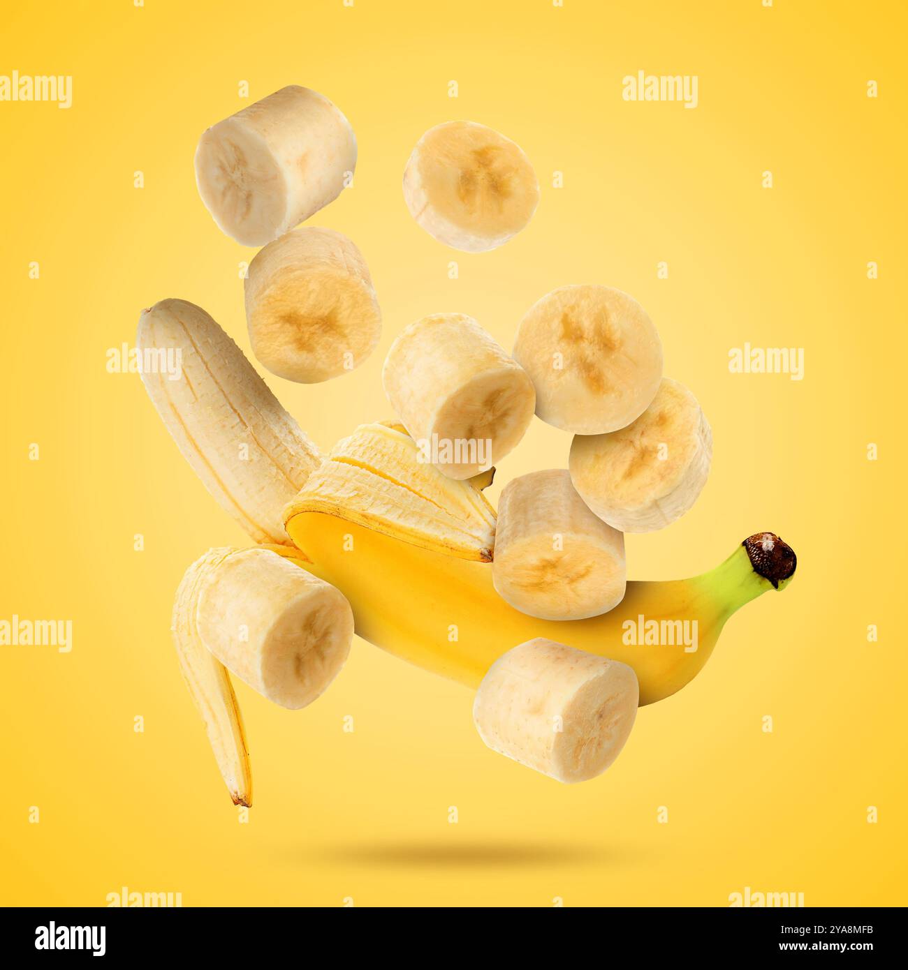 Fresh ripe bananas falling on golden background Stock Photo - Alamy