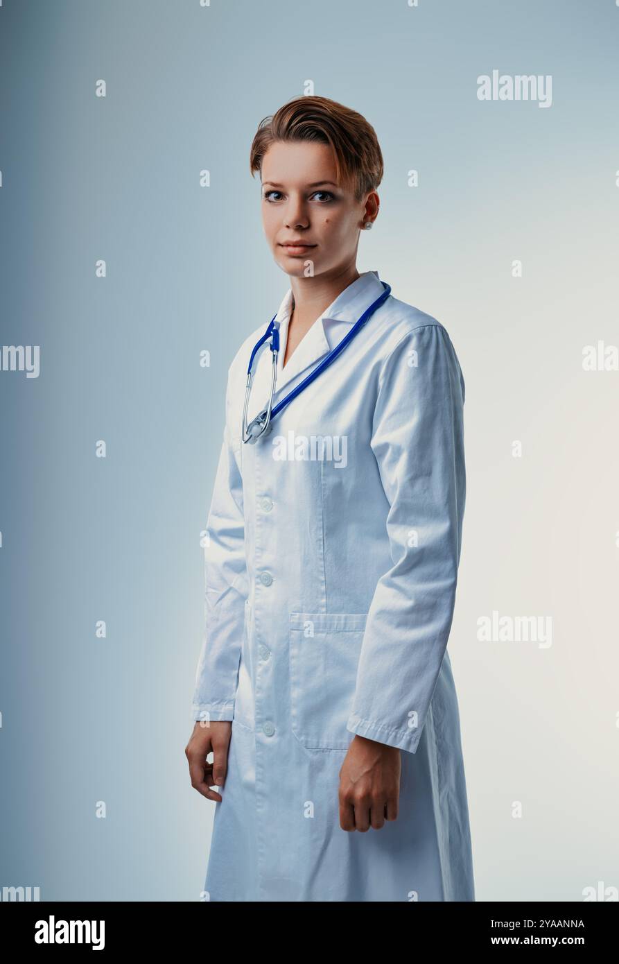 Young doctor woman with short hair wearing a white coat and stethoscope ...