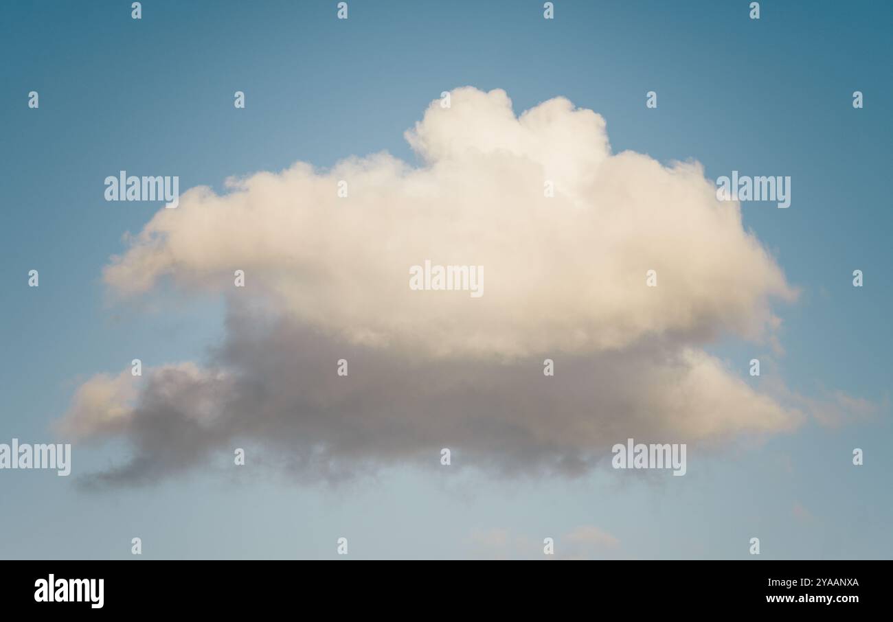 A single fluffy white cloud with soft edges floats peacefully in a ...