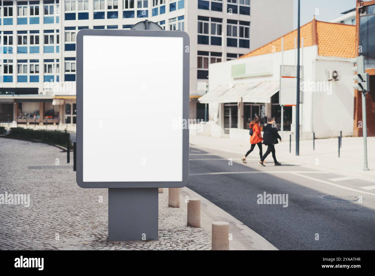 A blank billboard mockup stands prominently on a pedestrian sidewalk ...
