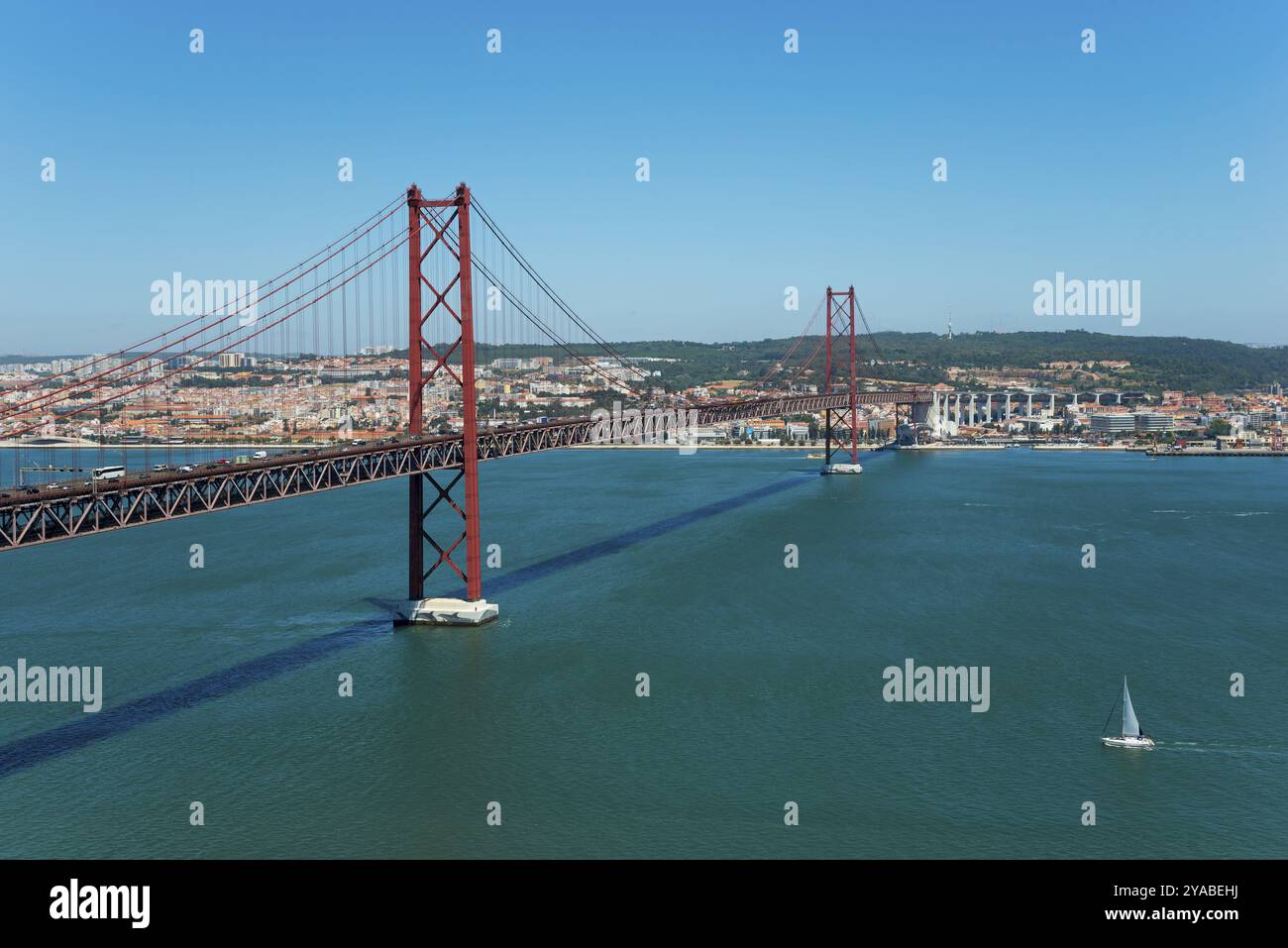 Panoramic view of a large red bridge over a wide river under a clear ...